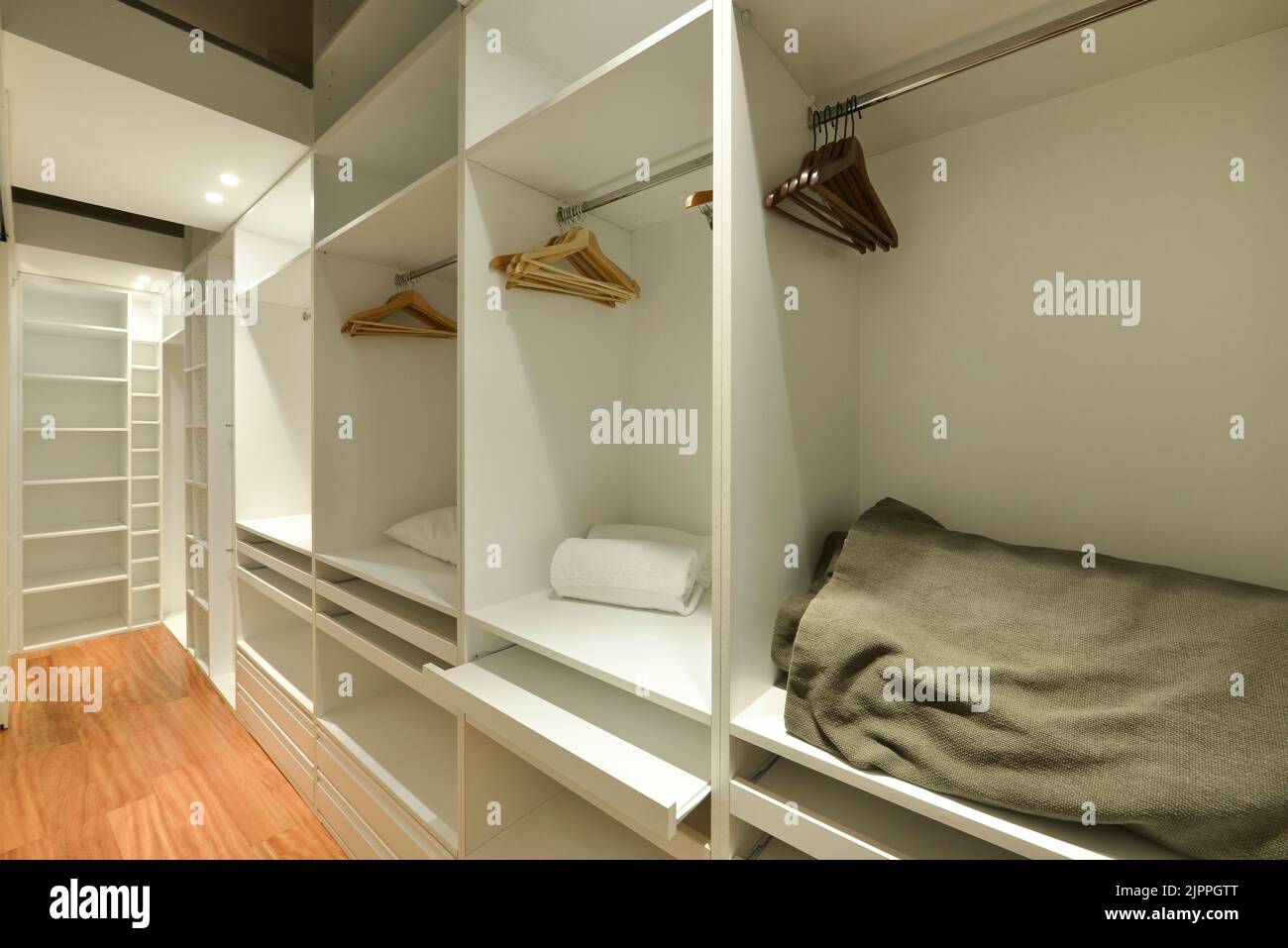 Walk-in closet with many shelves, clothes rails and tie and shirt ...