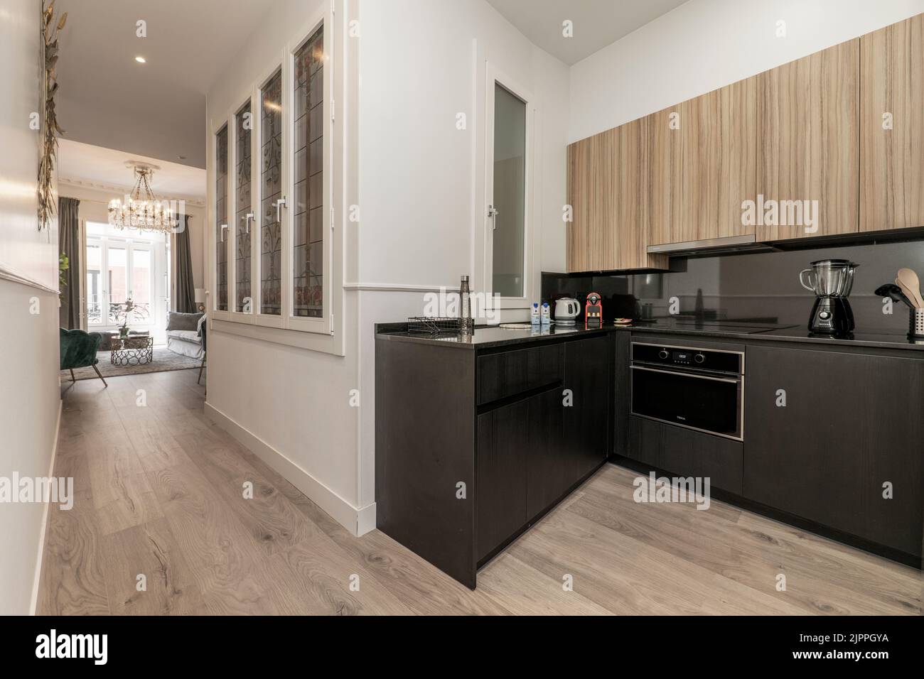 Open kitchen with black wooden base units and natural color wall units ...