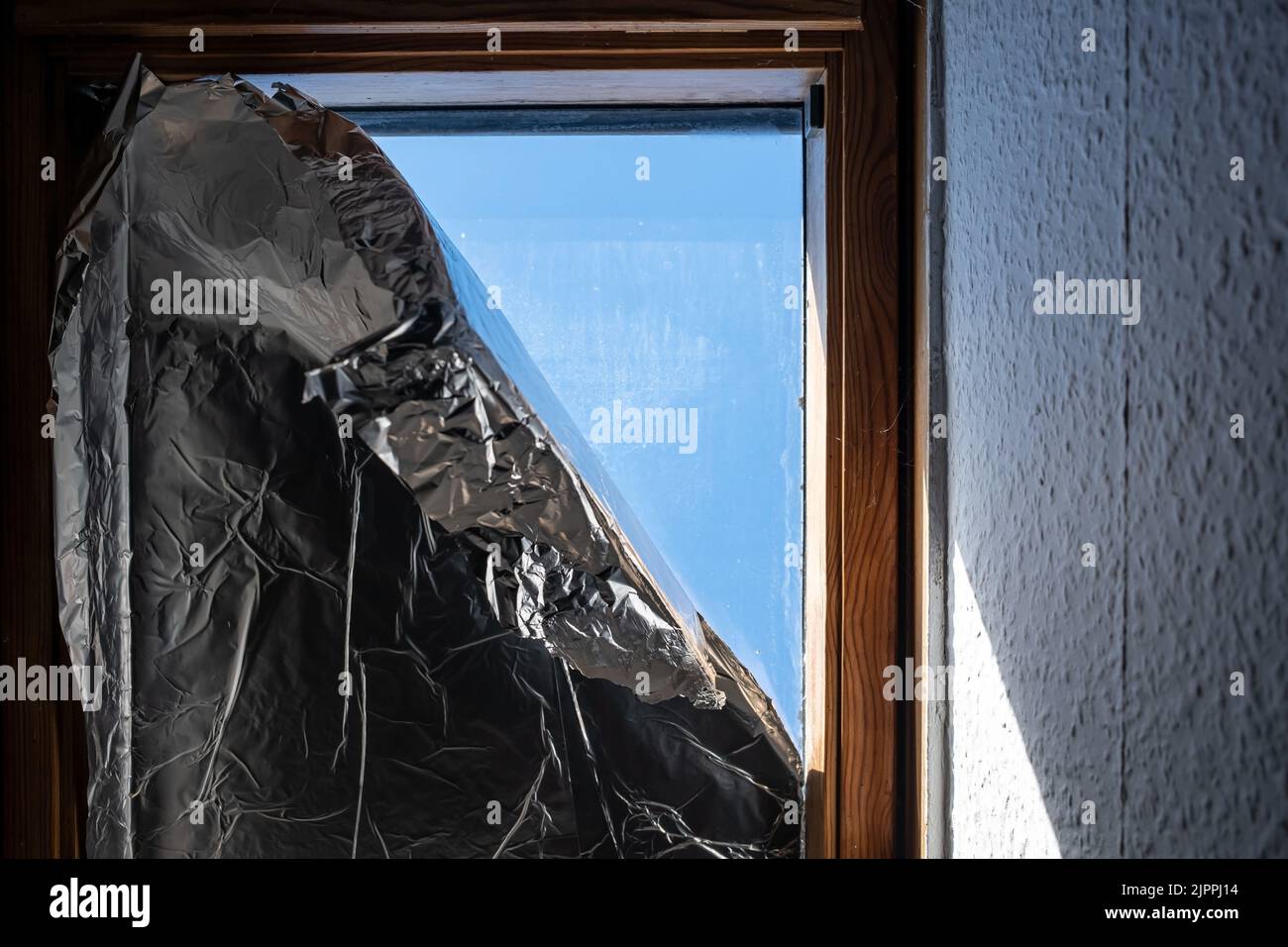 Window covered with foil to prevent sunlight from entering house during ...