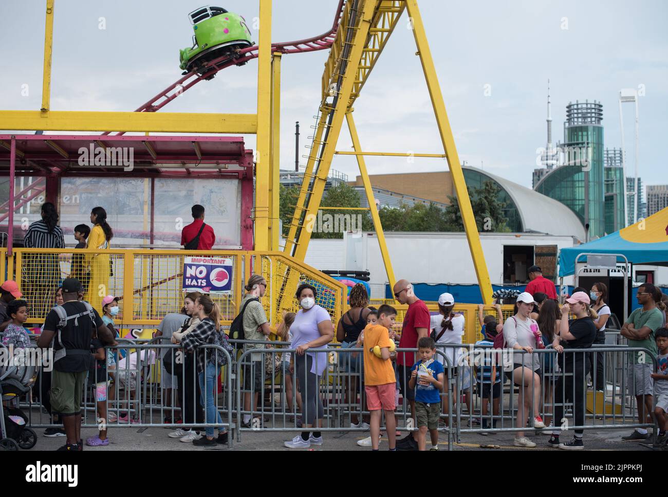 People wait in line for a family friendly ride during opening day of ...