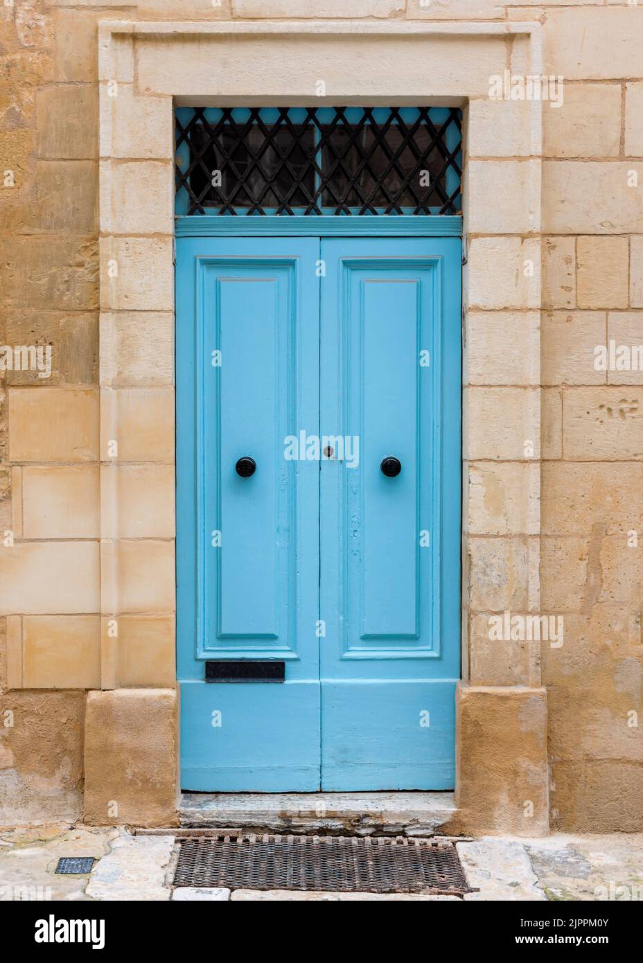 A vertical shot of a vintage blue front door of a brick building in ...