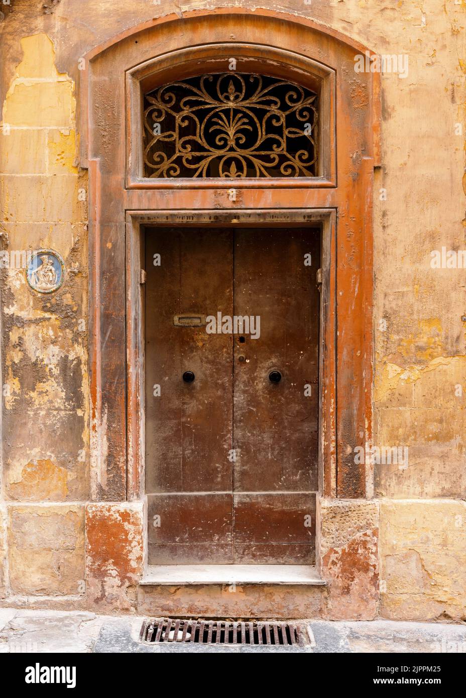 A vertical shot of a vintage brown front door of a yellow brick ...