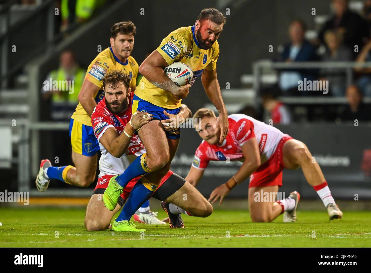 Kane Linnett #12 of Hull KR is tackled by Alex Walmsley #8 of St Helens ...