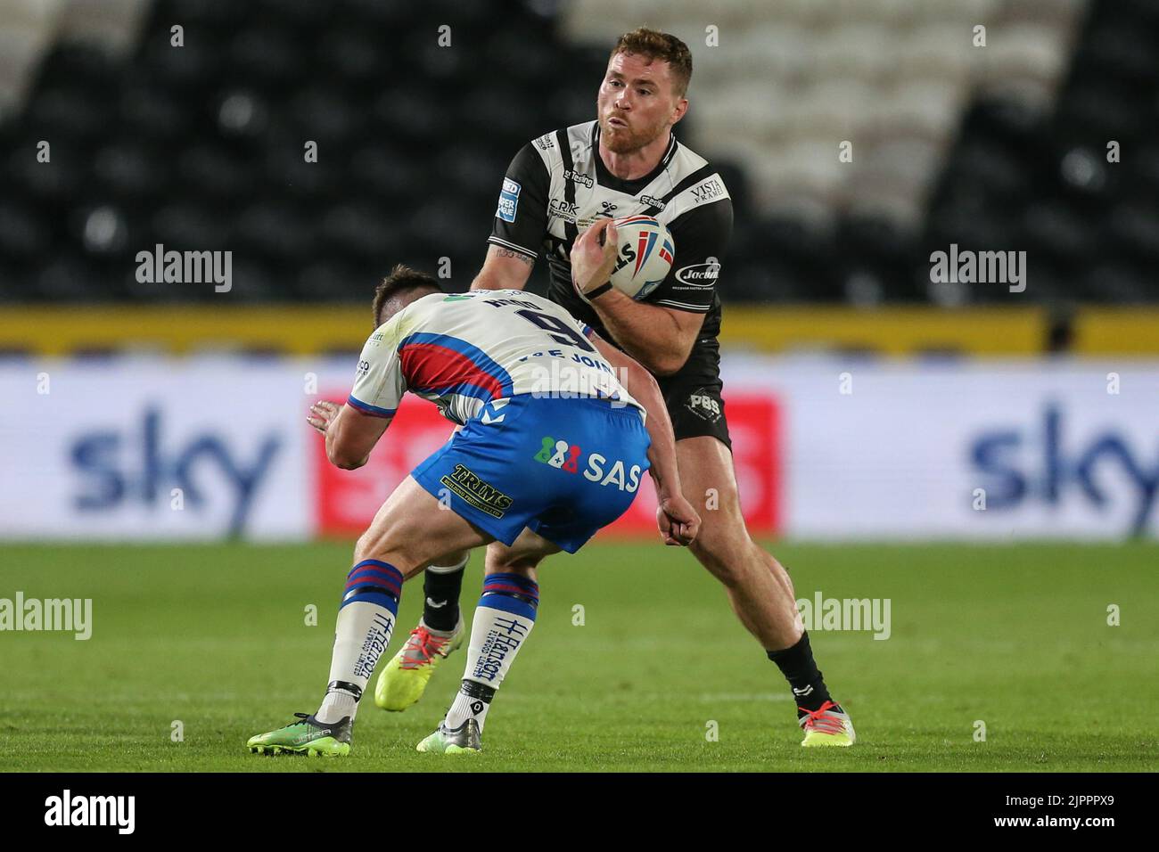 Scott Taylor #30 of Hull FC is stopped by Liam Hood #9 of Wakefield ...