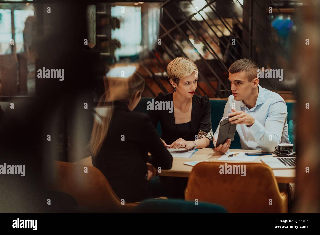 Happy businesspeople smiling cheerfully during a meeting in a coffee ...