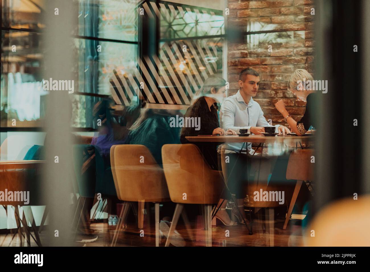 Happy businesspeople smiling cheerfully during a meeting in a coffee ...