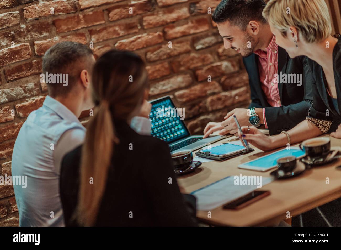 Happy businesspeople smiling cheerfully during a meeting in a coffee ...
