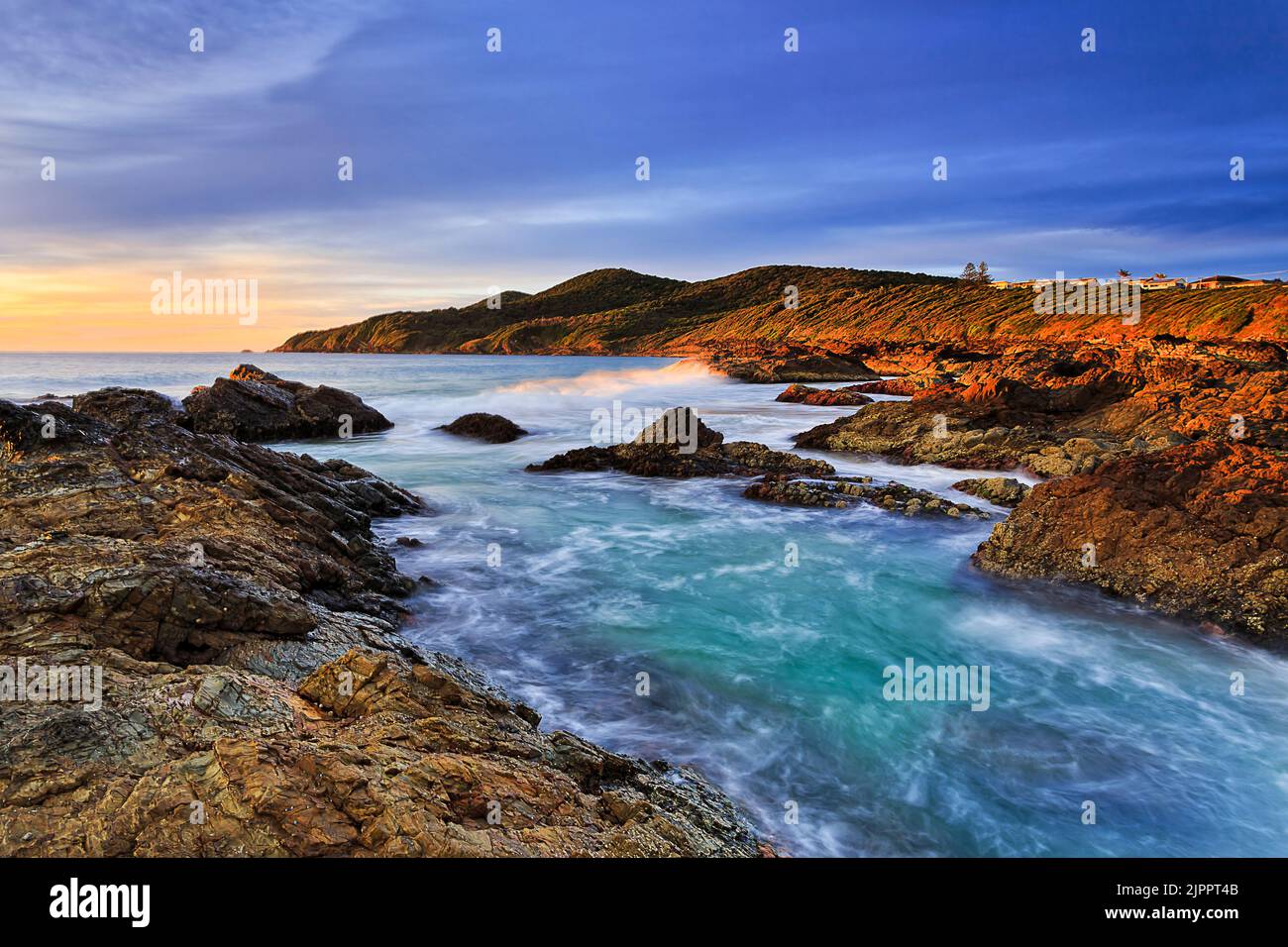 Sun lit sandstone rocks on Burgess beach of Forster town in Australia ...