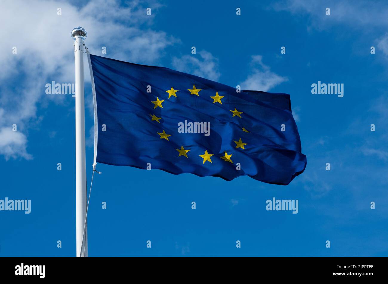 Flag of EU on blue sky background. European Union flag waving in wind ...