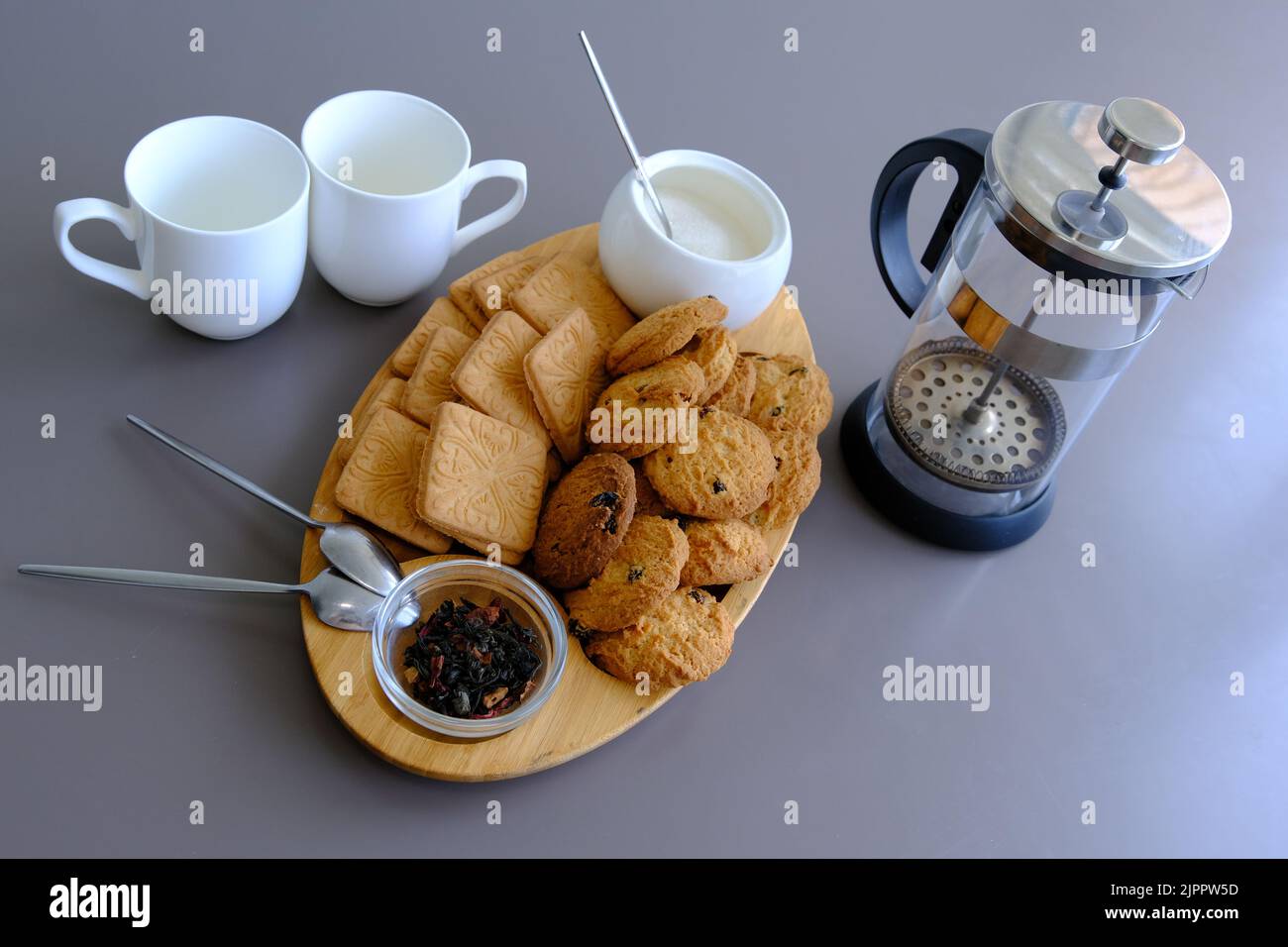 A tasty snack two cups of black tea and a plate of oatmeal cookies a ...