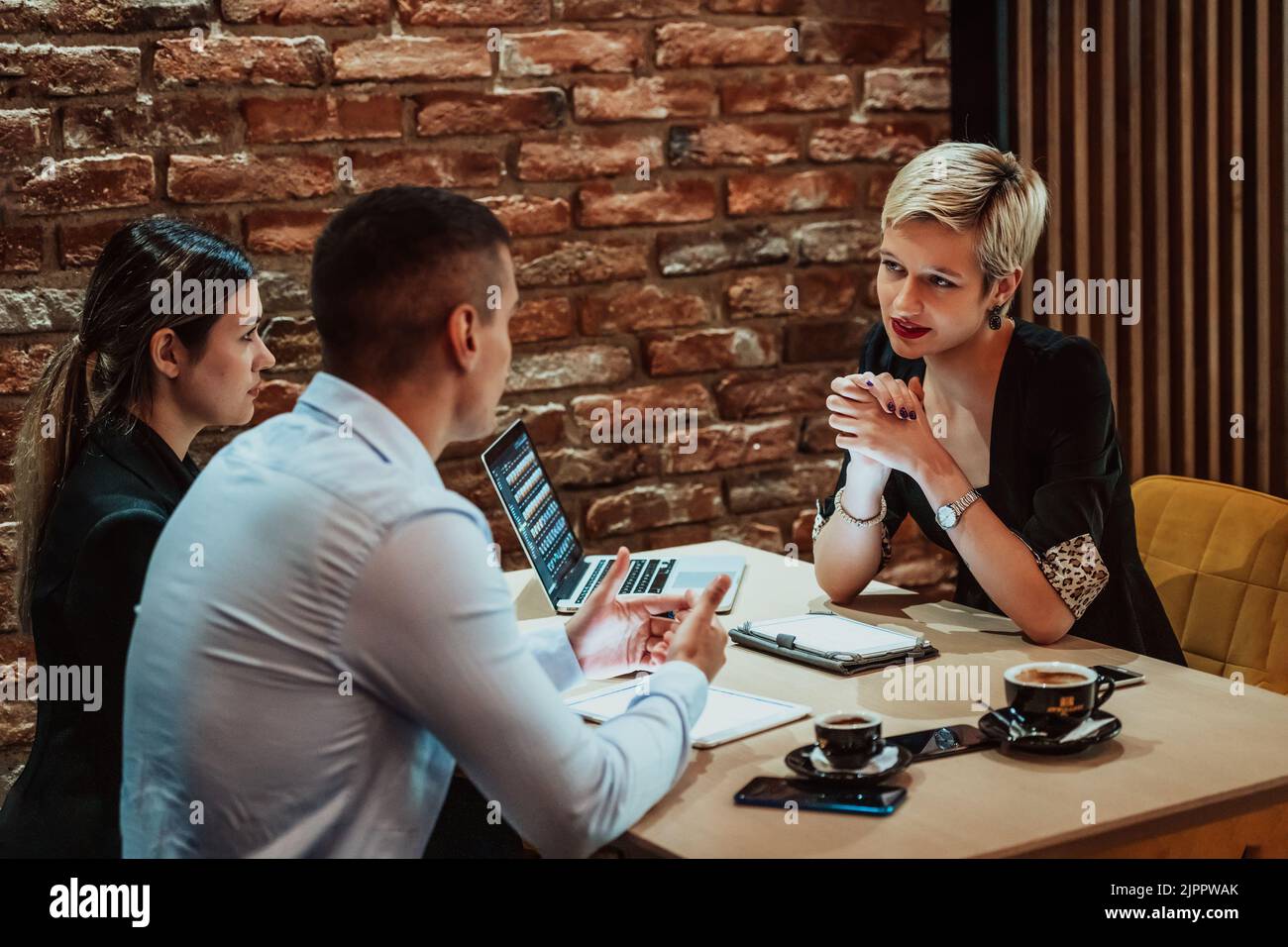 Happy businesspeople smiling cheerfully during a meeting in a coffee ...
