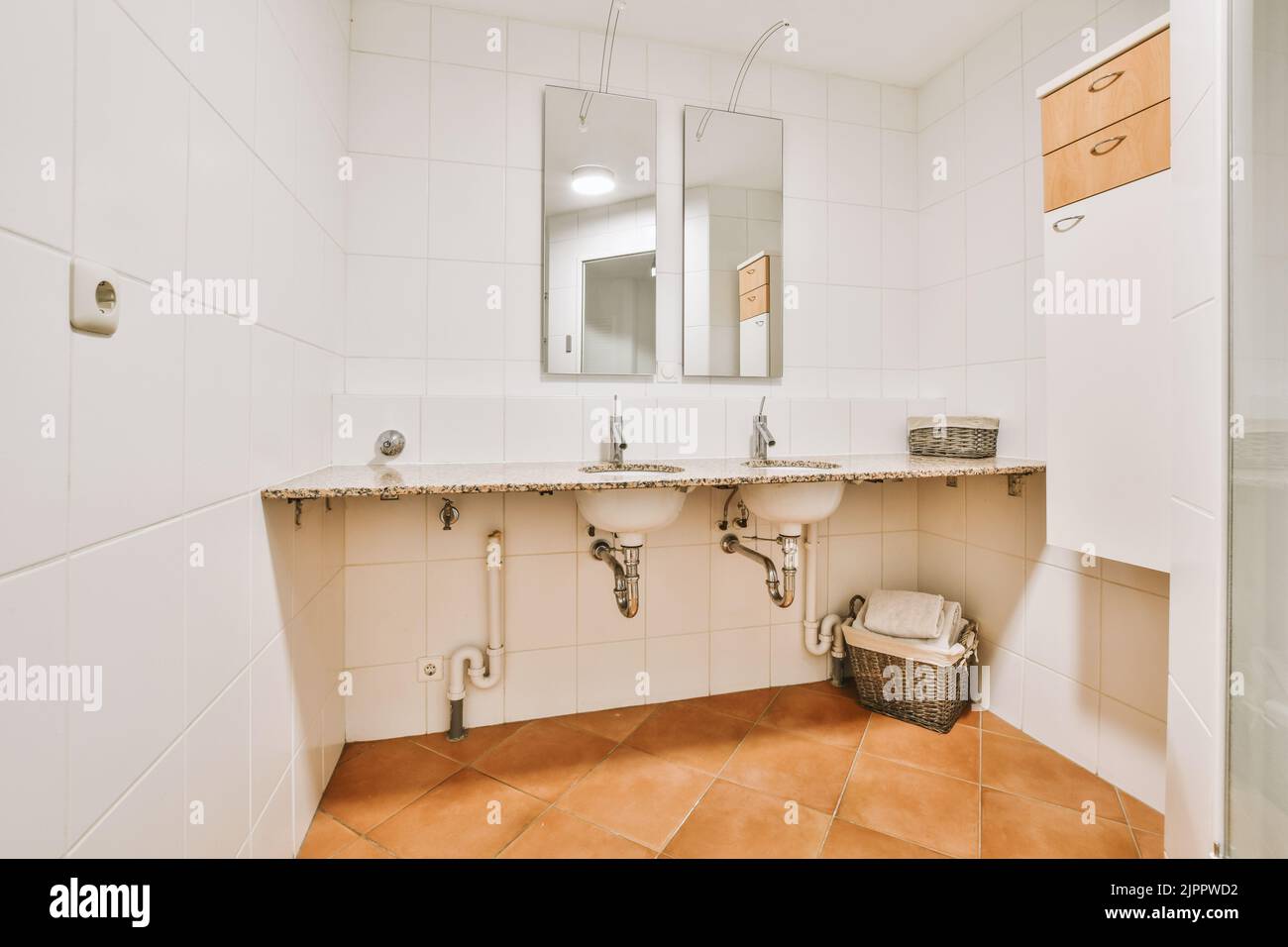 Sink with tap and liquid soap hanging on tiled wall under mirror in ...