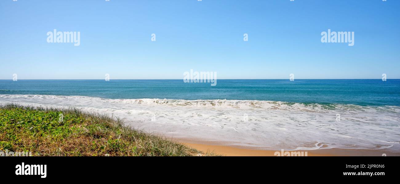 Foam from backwash from ocean waves breaking onto a sandy beach at ...