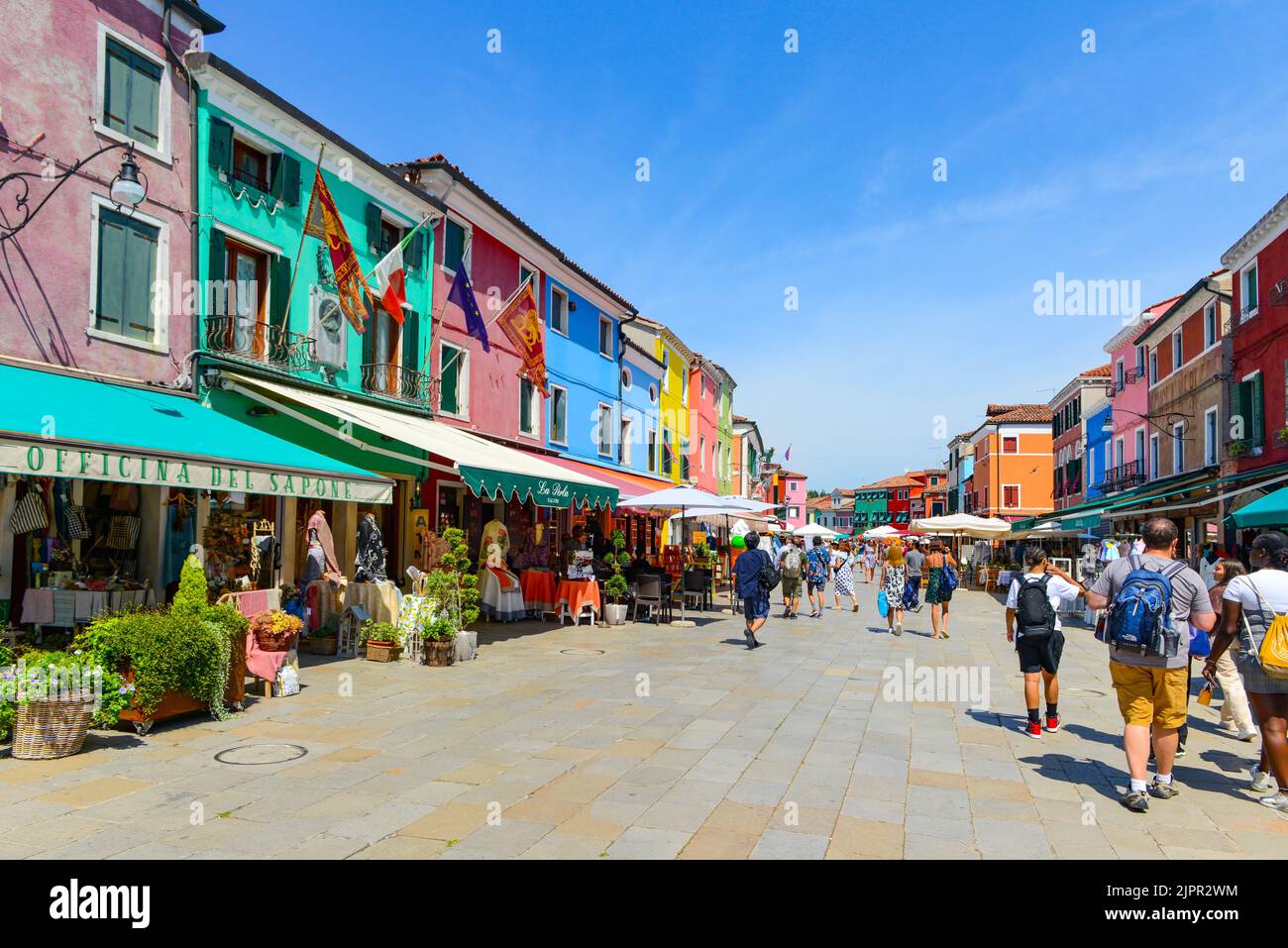 BURANO ISLAND, VENICE, ITALY - JULY 4, 2022: Tourists among the sovereign shops and restaurants ...