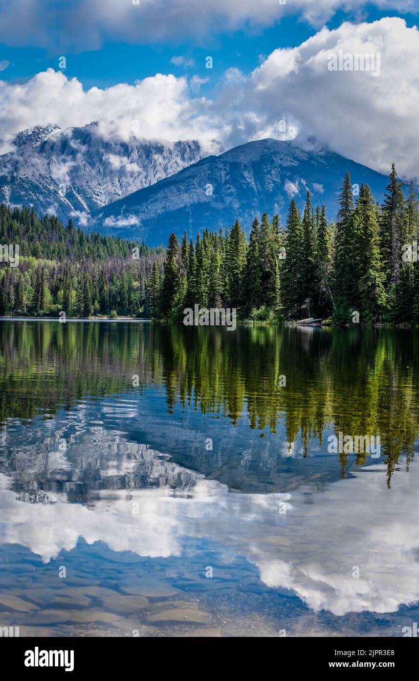 Reflections on Pyramid Lake in Jasper National Park with canoes nestled ...