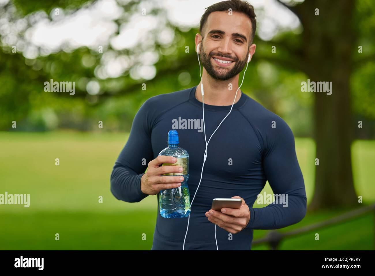 Music for motivation and water for hydration. Cropped portrait of a ...