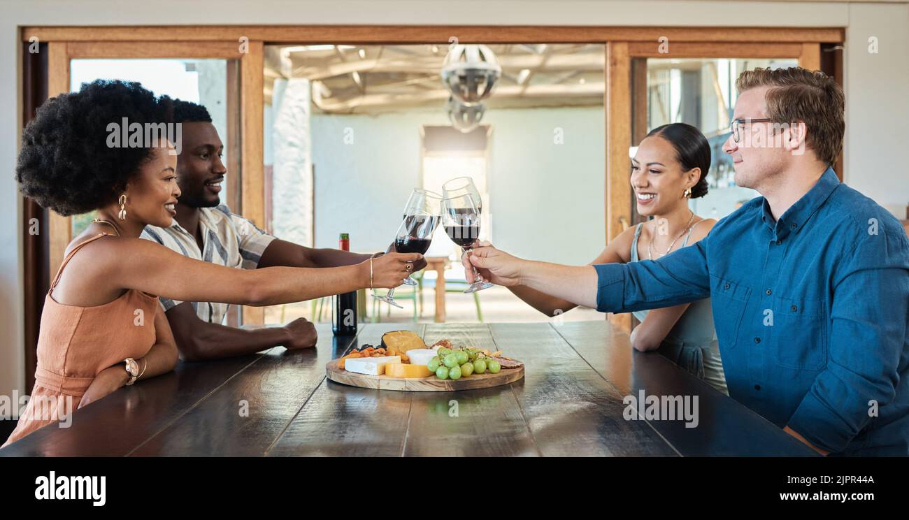 Double date of couples having dinner together and drinking wine at a ...