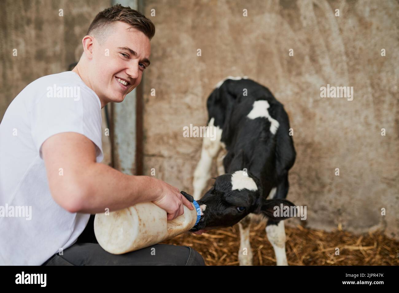 He loves his milk. Cropped portrait of a handsome young man feeding a ...