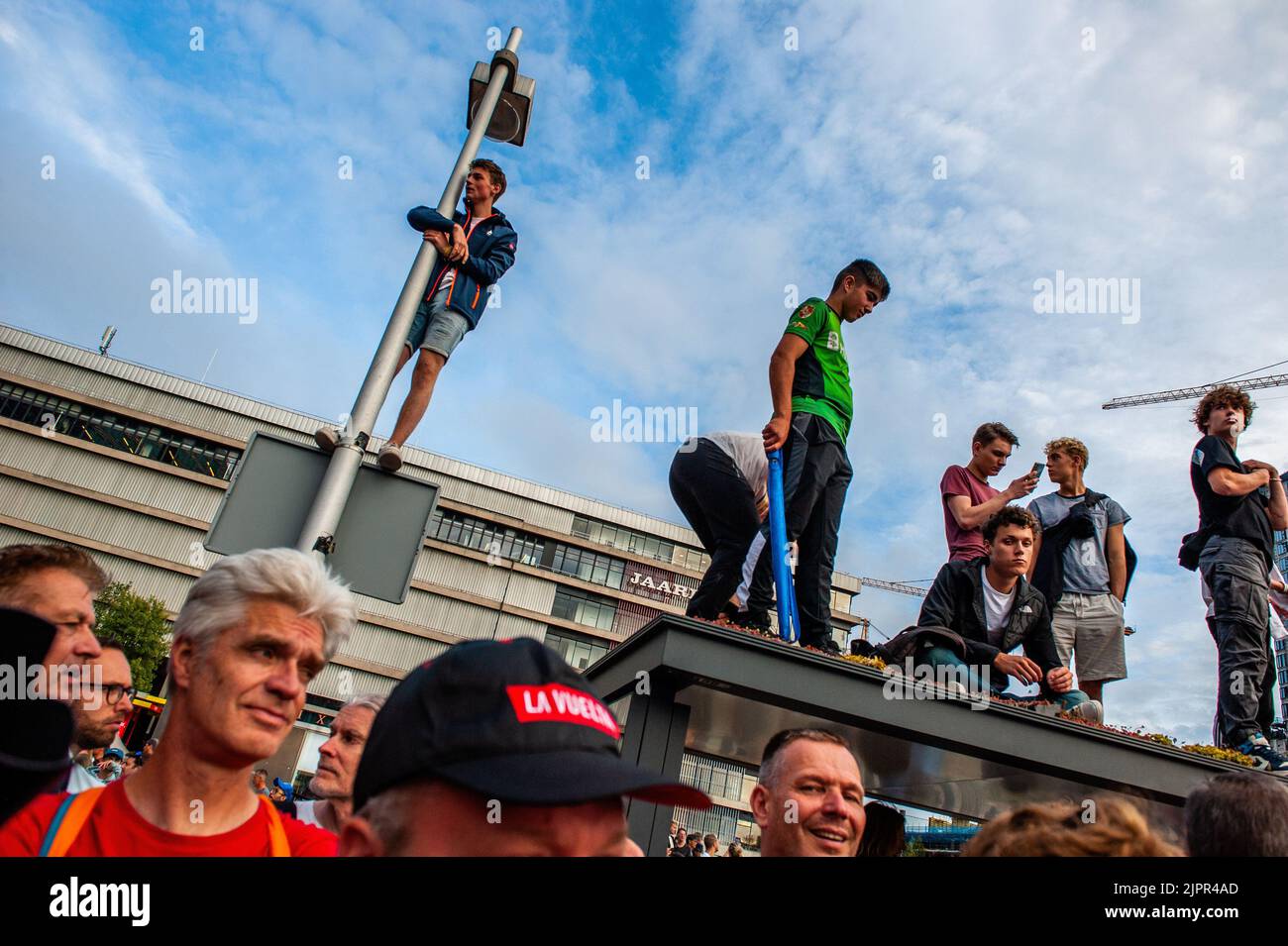 People are seen standing up over bus stops and traffic signs to watch ...