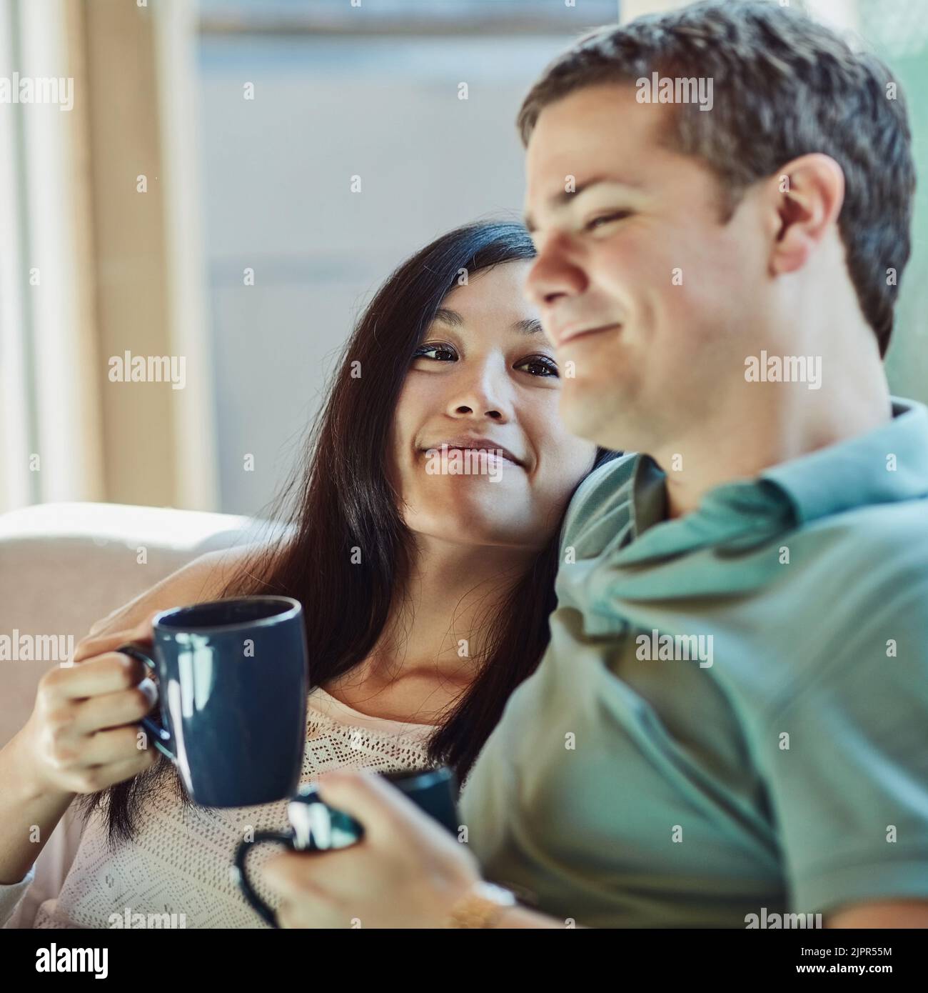 Im so happy by his side. a happy young couple relaxing on their couch ...