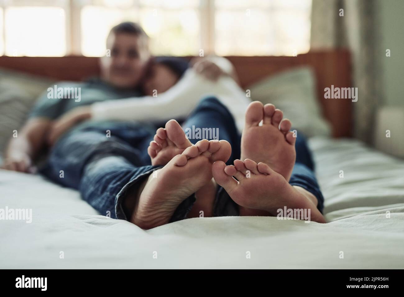I love it when your feet touches mine. a couples feet as they lay on ...