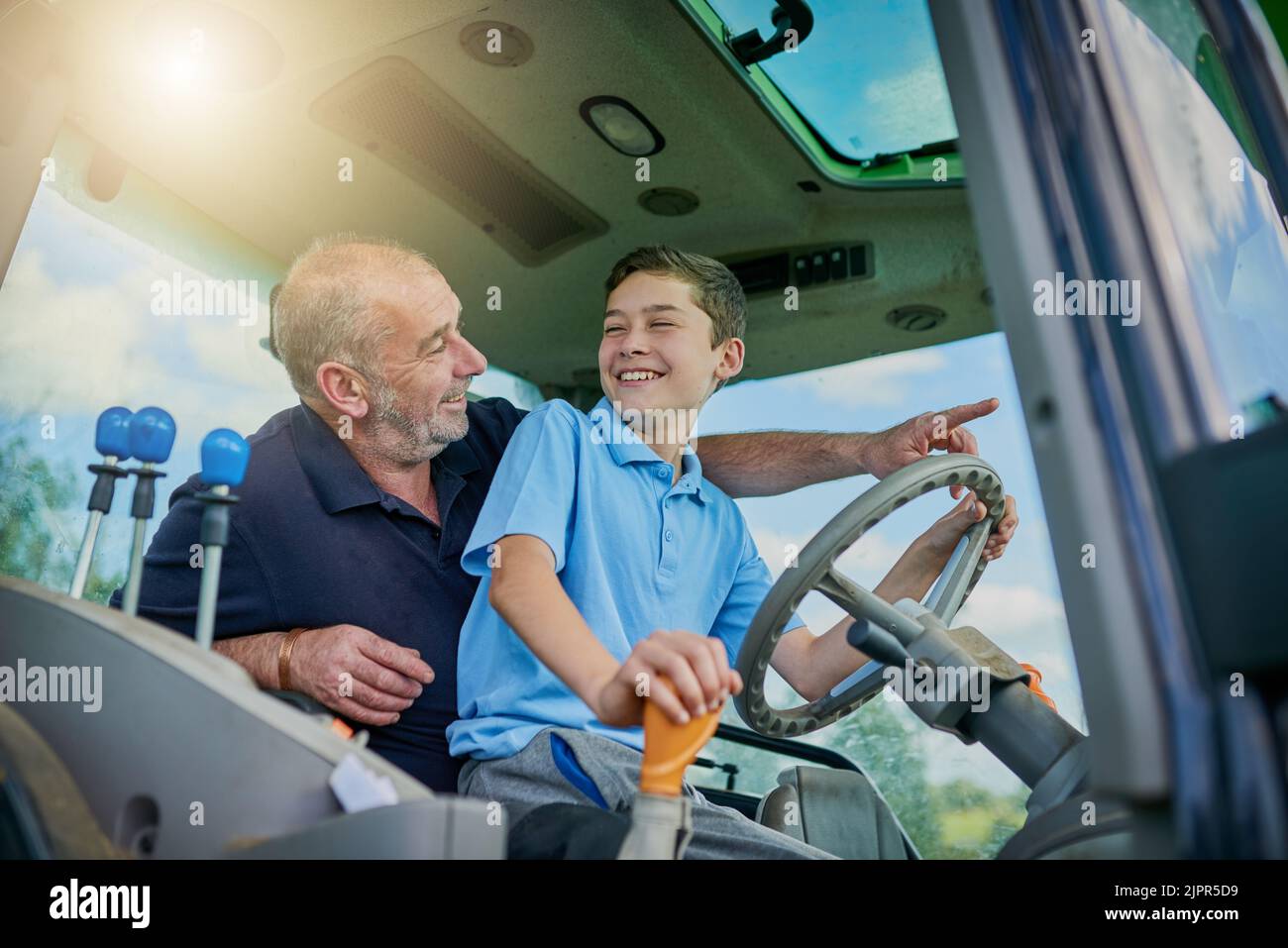 Eyes on the road. a male farmer and his son inside the cockpit of a ...