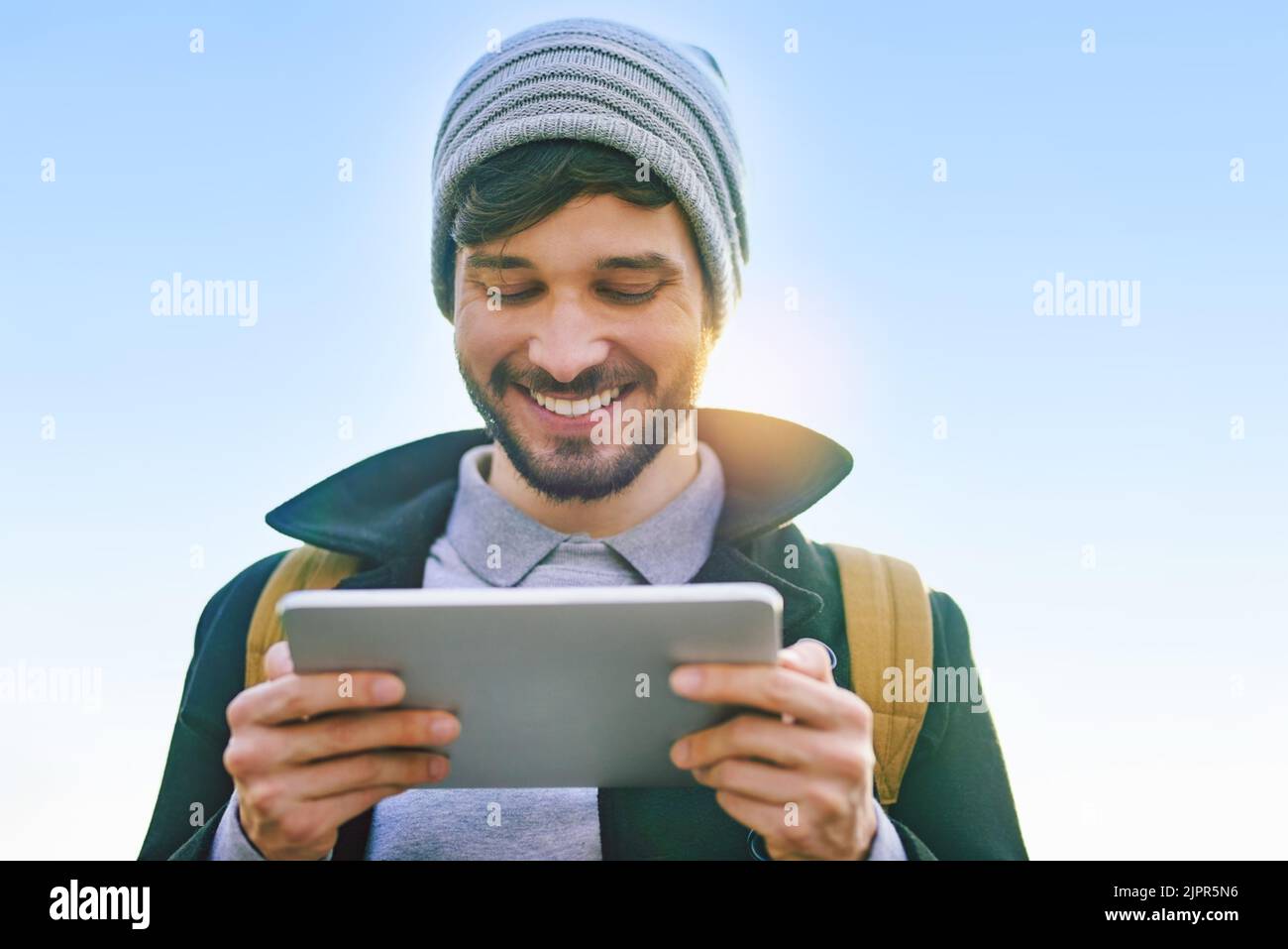 Connect and go places. a young man using a digital tablet outdoors ...