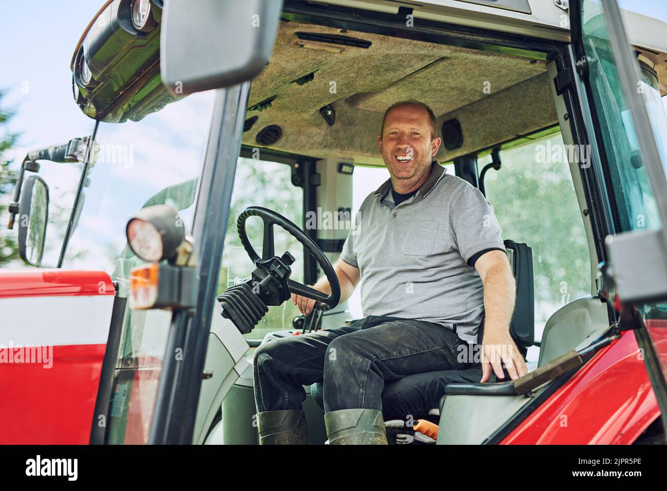 This tractor is a great help around the farm. Cropped portrait of a ...