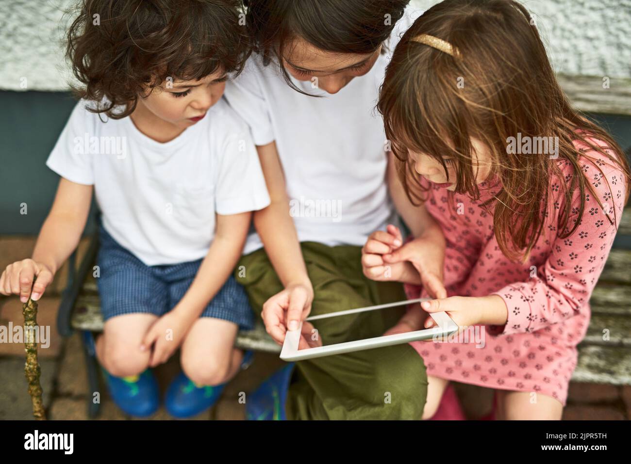 Engaged in a whole wide world online. three adorable little children ...