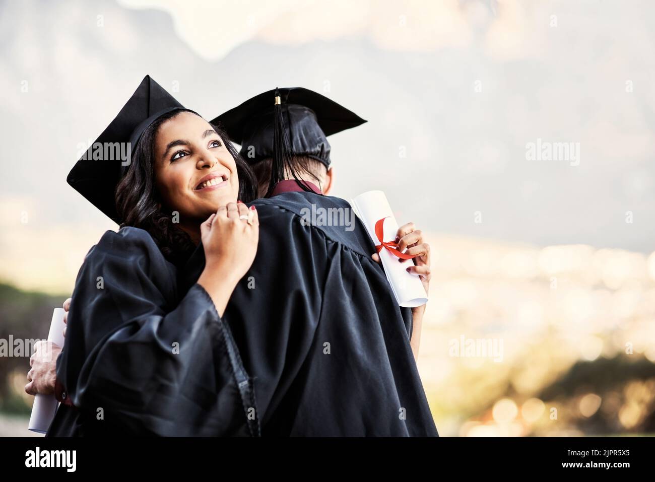 We did it. two students hugging each other on graduation day Stock ...