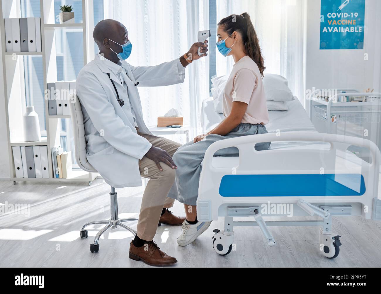 Doctor checking temperature of sick covid patient to test for fever ...