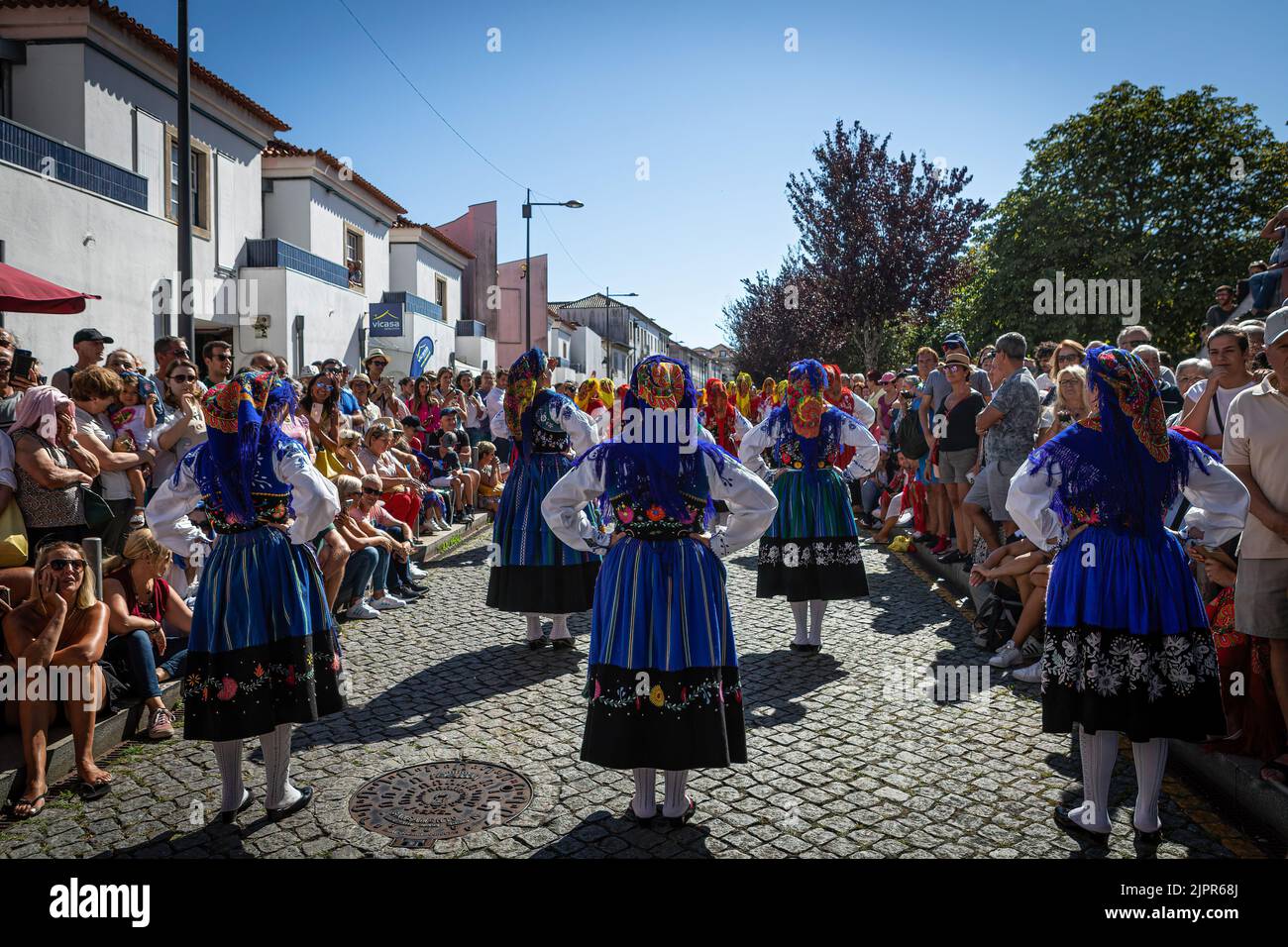 Women wearing traditional costumes walk the parade. More than half a ...