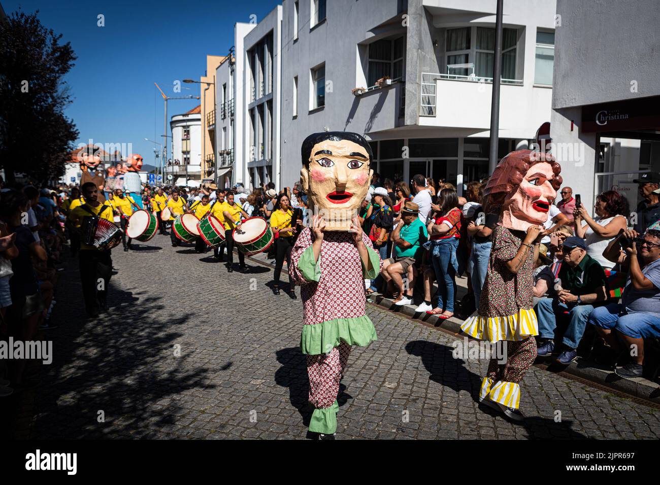 Two big-headed puppets run as the groups of drummers come. More than ...