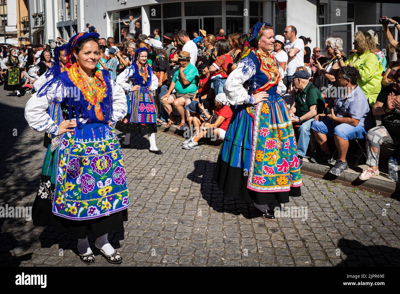 Women wearing traditional blue and black costumes are seen walking the ...
