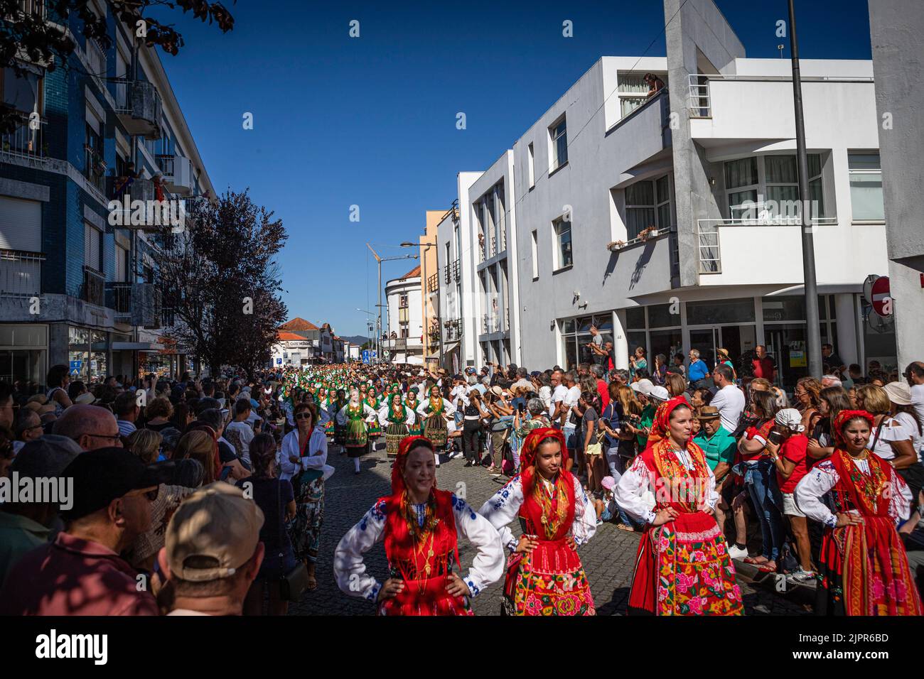 Women are seen walking the parade in traditional costumes. More than ...