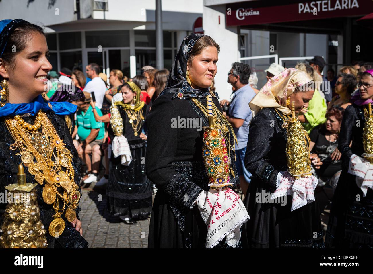 Mordomas dressed in black holding votive candles in their hands. More ...
