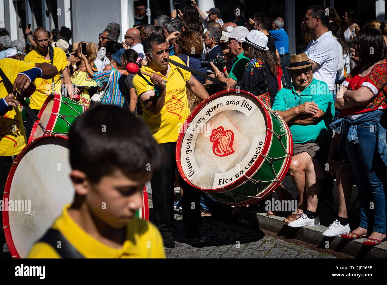 A drummer plays the drum with the saying "quem gosta vem, quem ama fica ...