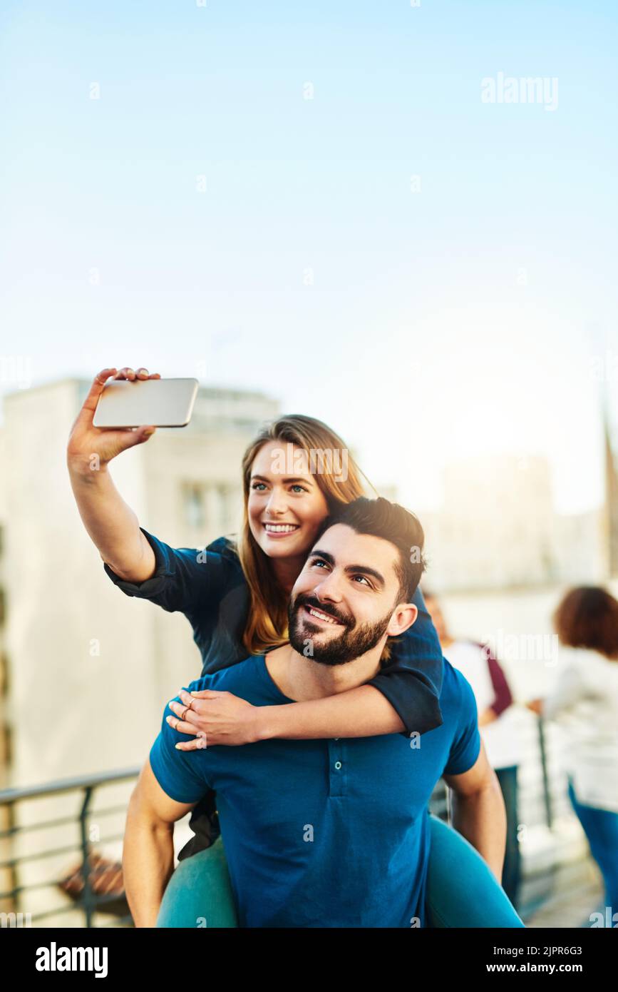 Sharing this selfie later. a young couple taking a selfie outside Stock ...