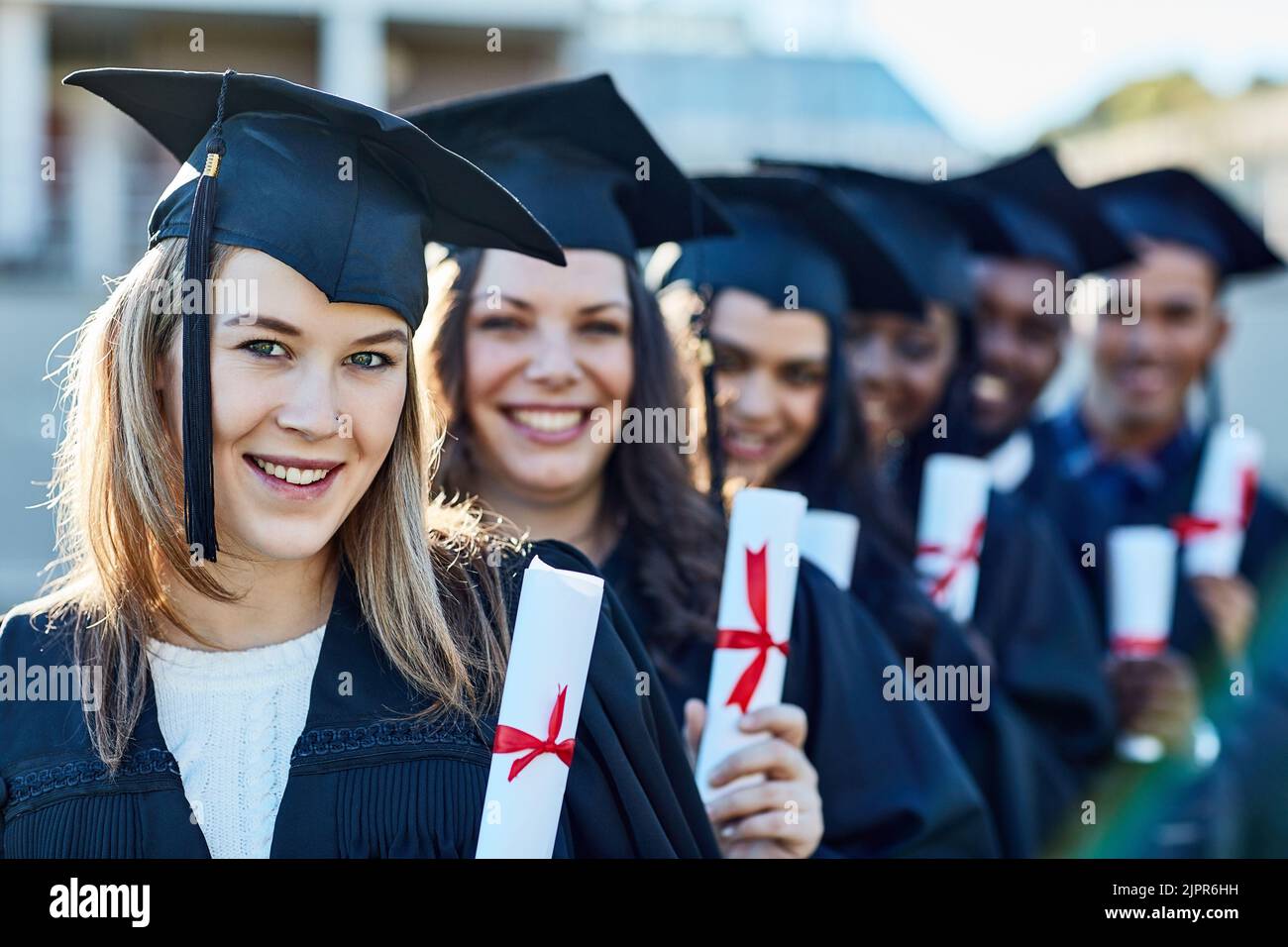 These are our keys to success. Portrait of a group of students standing ...