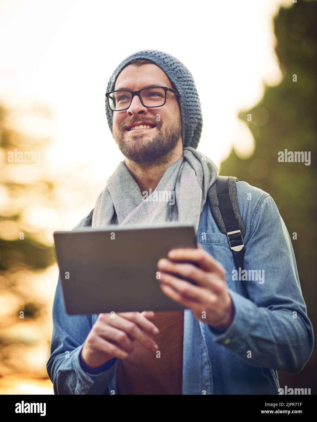 Connected to the outside world. a handsome young man using a tablet ...