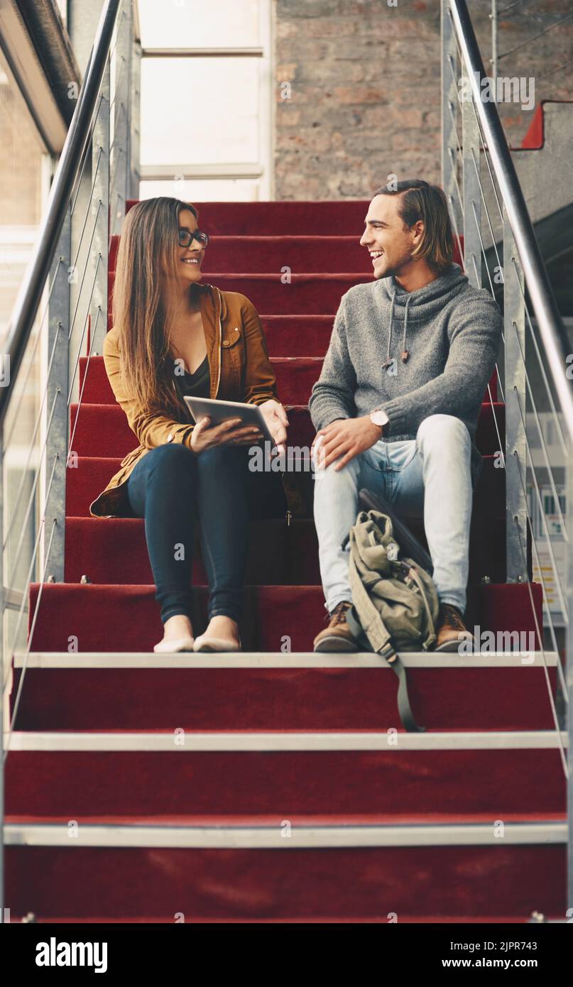 Chatting on campus. Full length shot of two young university students ...