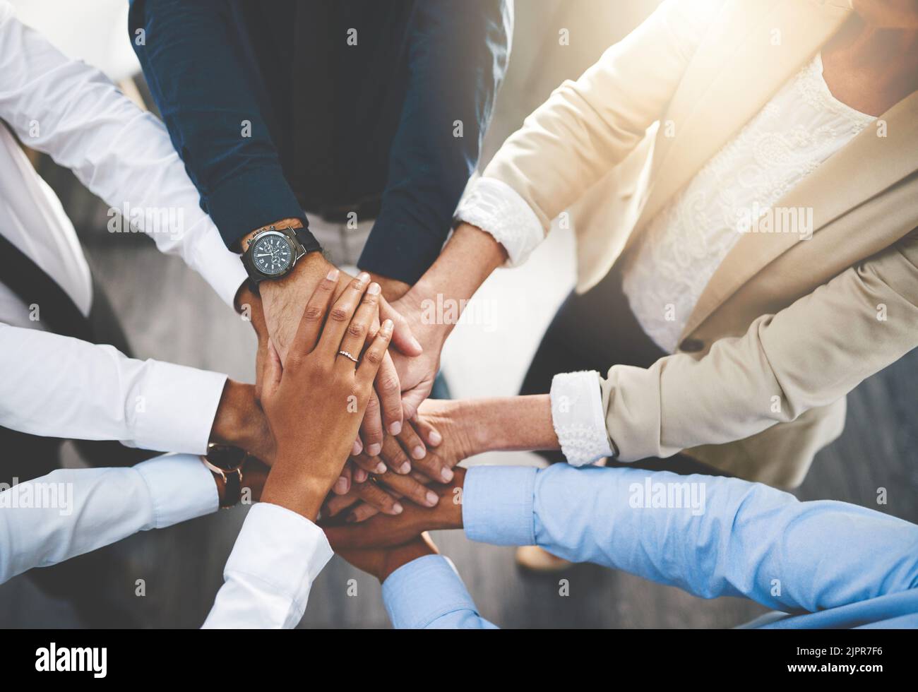 Working in unity. a group of unrecognisable businesspeople joining ...