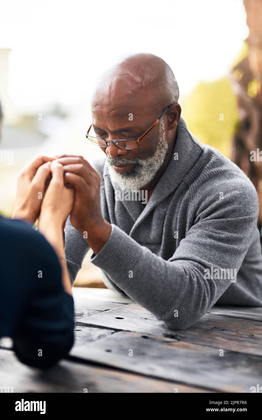 Spending a little time in prayer. a senior couple holding hands in ...
