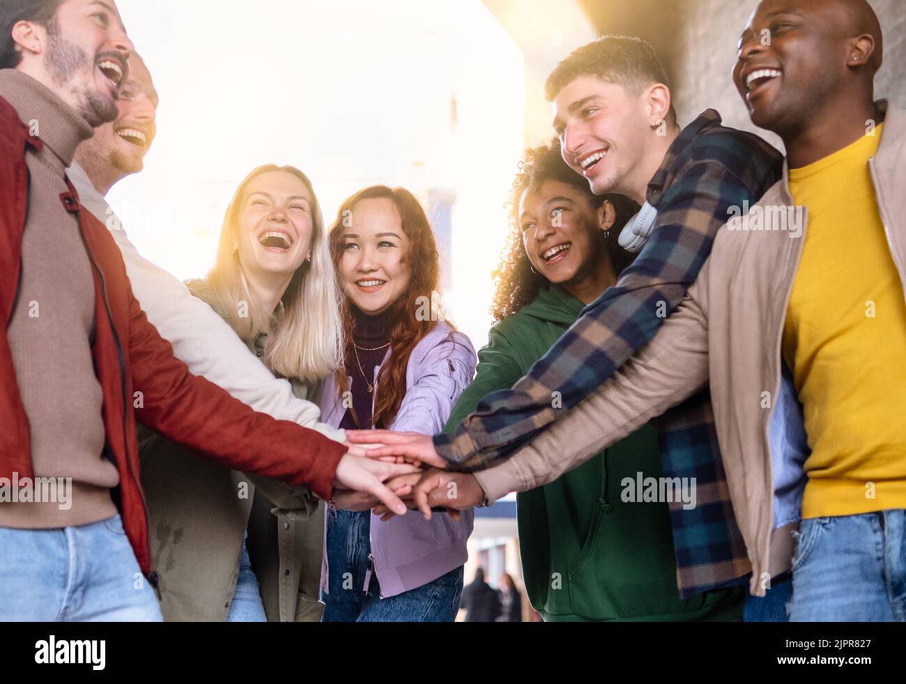 Multiracial happy friends with hands in stack. Multi-ethnic diverse group joining their hands ...