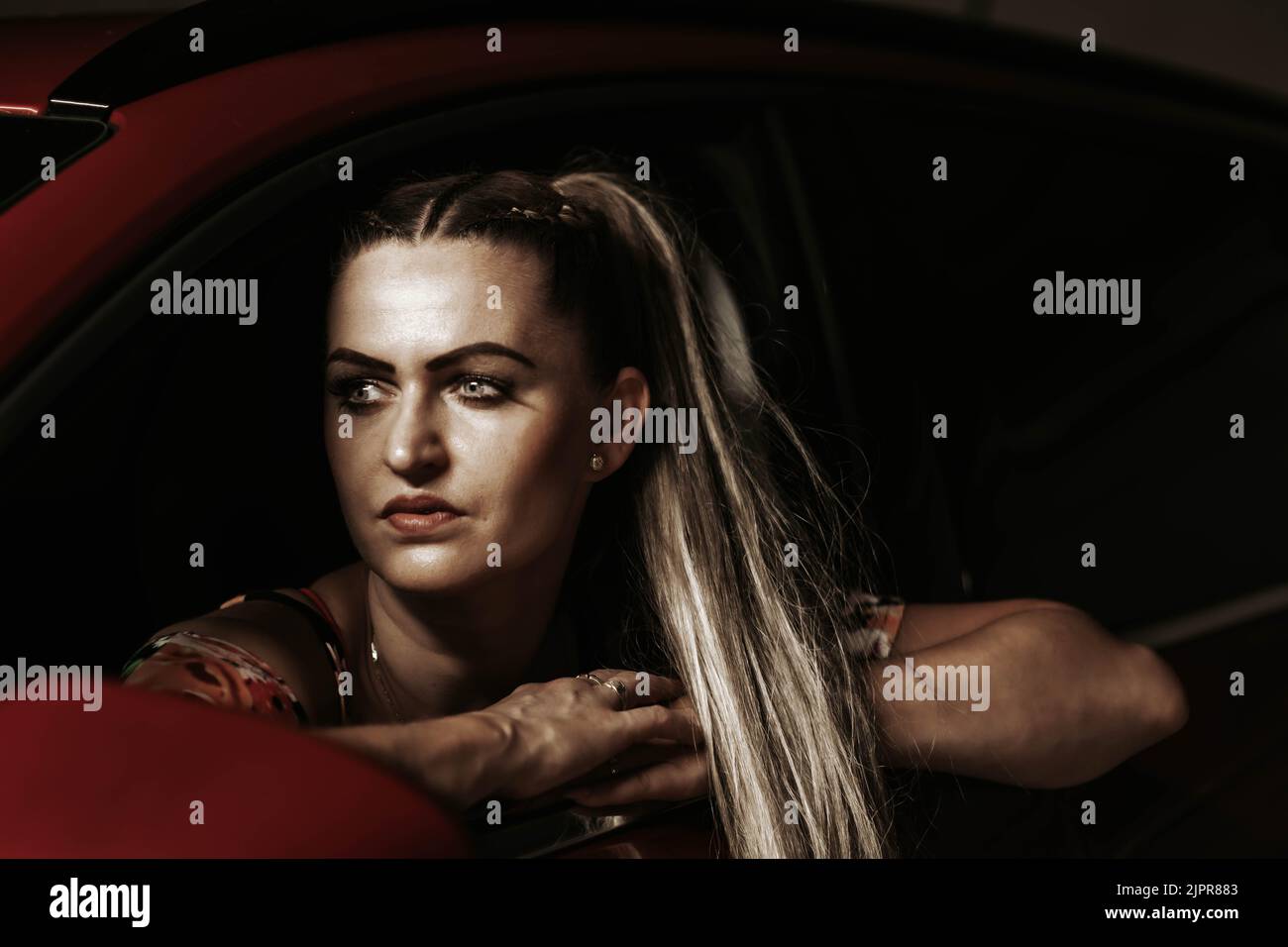 Beautiful lady possing with red fiat tipo in dark garage with cinematic ...