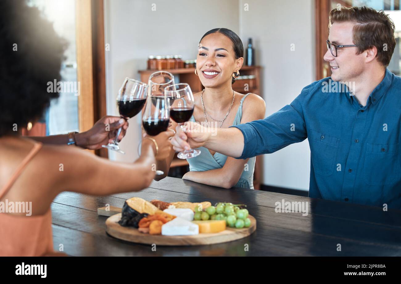 Friends, fun and celebration with diverse group toasting with red wine ...