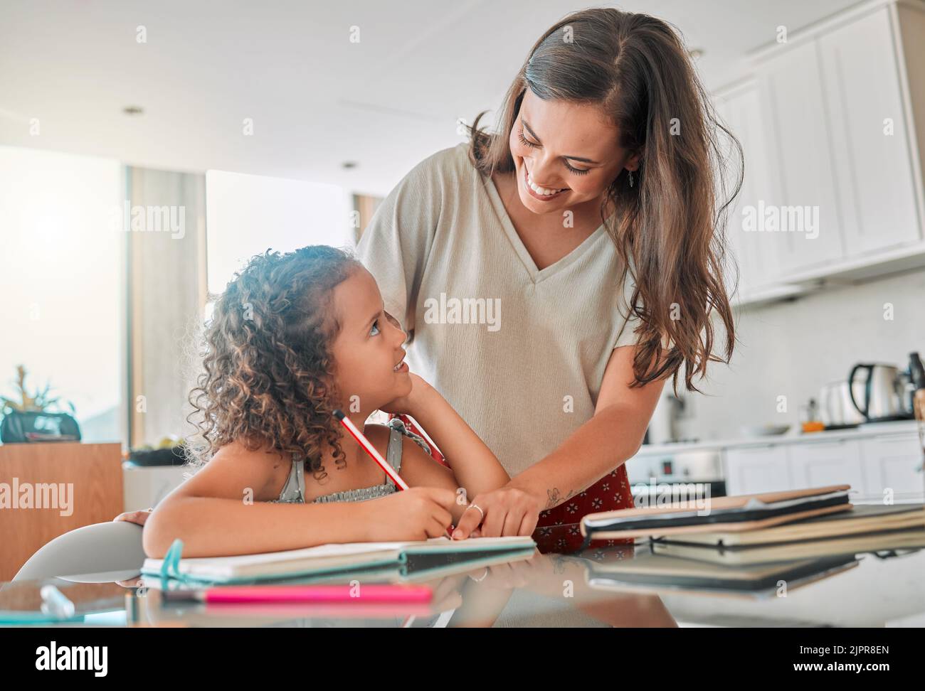 Homeschool, learning and bonding with a mother and daughter doing homework in the kitchen at ...