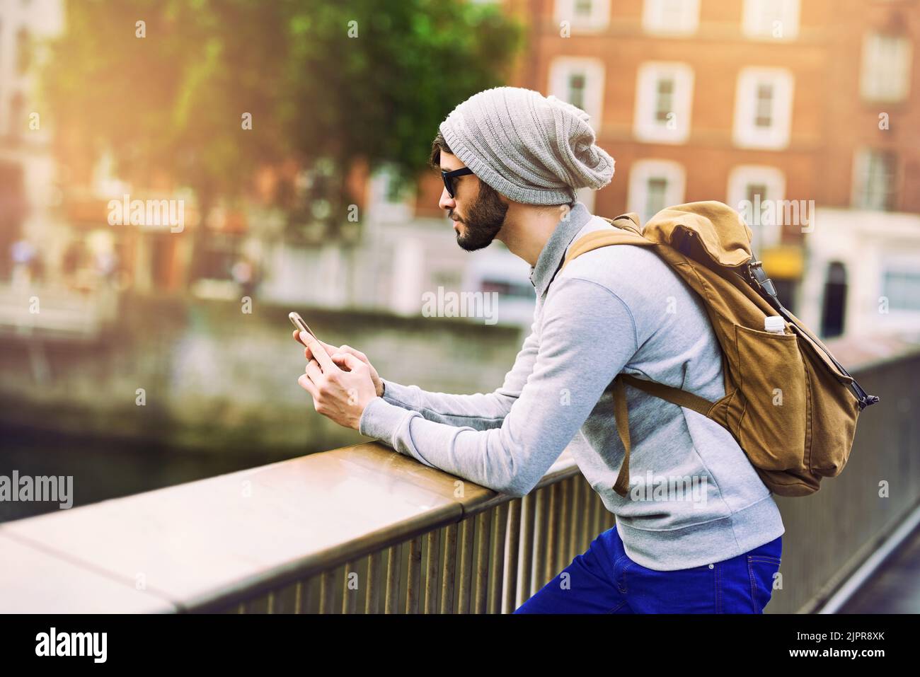 Connected the way the city demands. a young man using his mobile phone ...