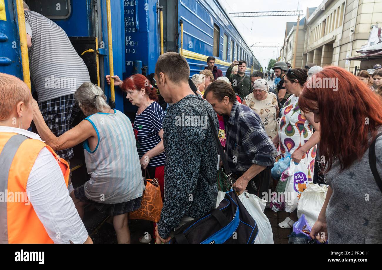 A group of old people, women and children boarding an evacuation train ...