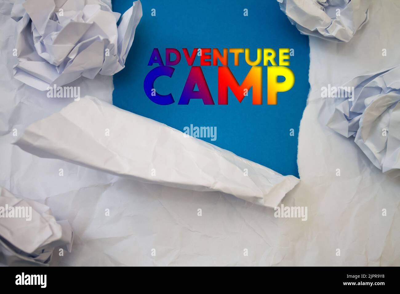 Adventure Camp text with Torn, Crumpled White Paper on colored ...